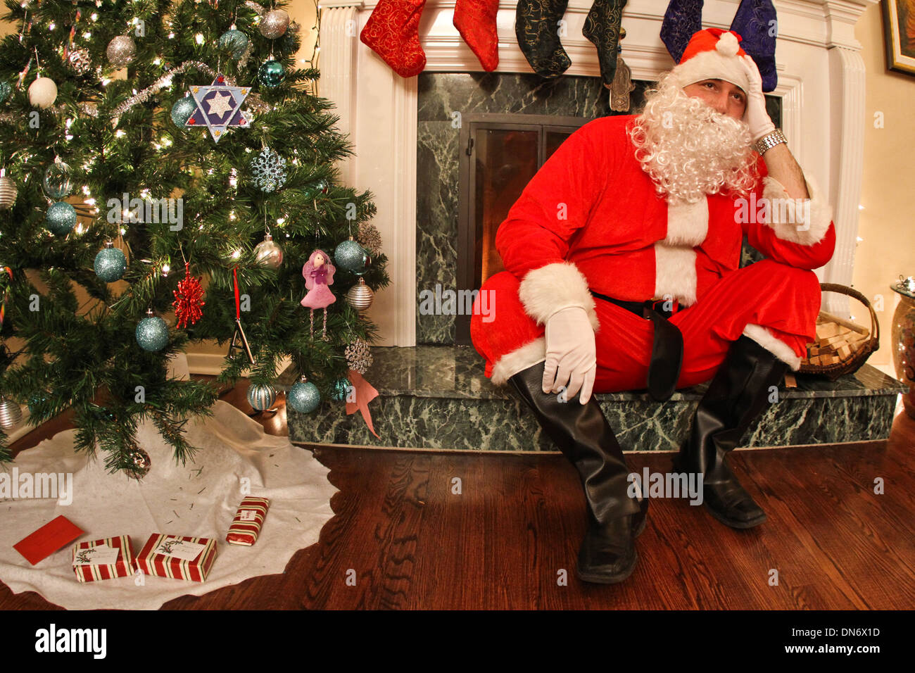 A stressed out Santa Clause sitting on a fire place mantel Stock Photo ...