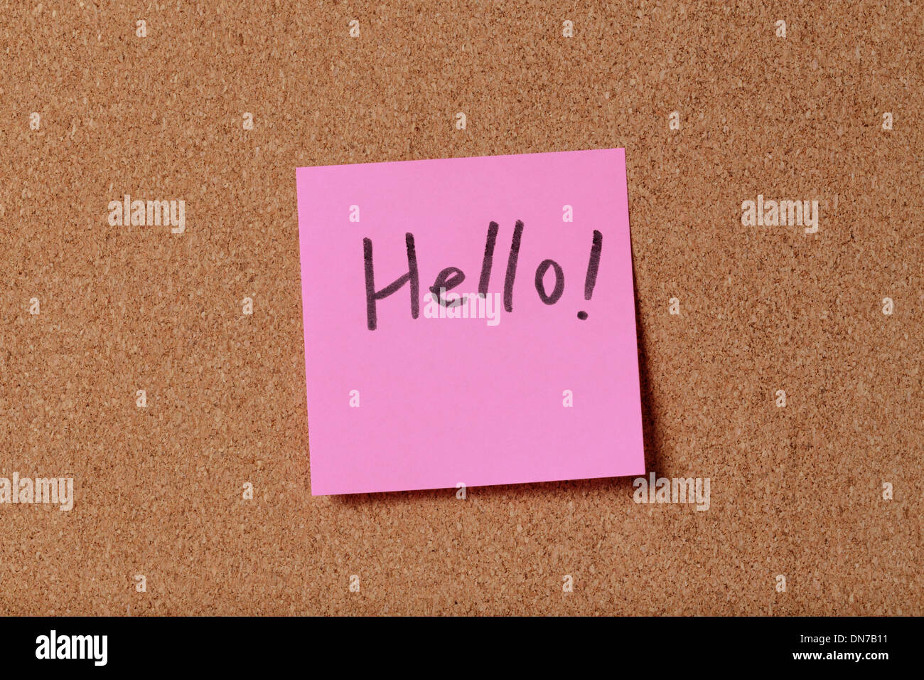 pink reminder sticky note on cork board hello word Stock Photo - Alamy