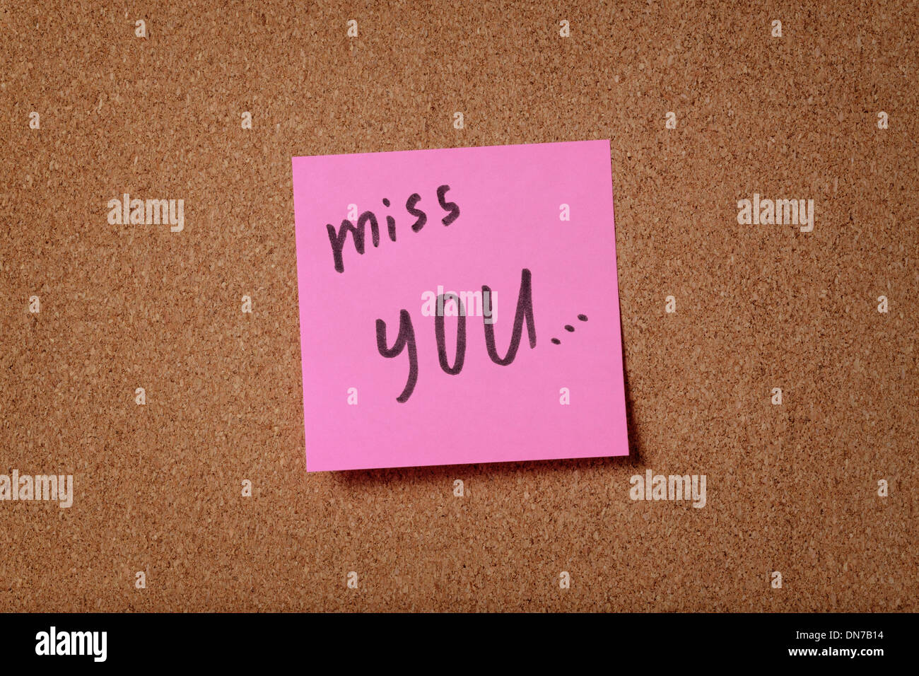 pink reminder sticky note on cork board miss you phrase Stock Photo - Alamy