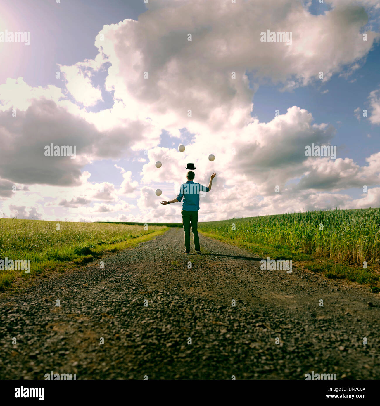 Young man with floating hat juggling in the field Stock Photo - Alamy