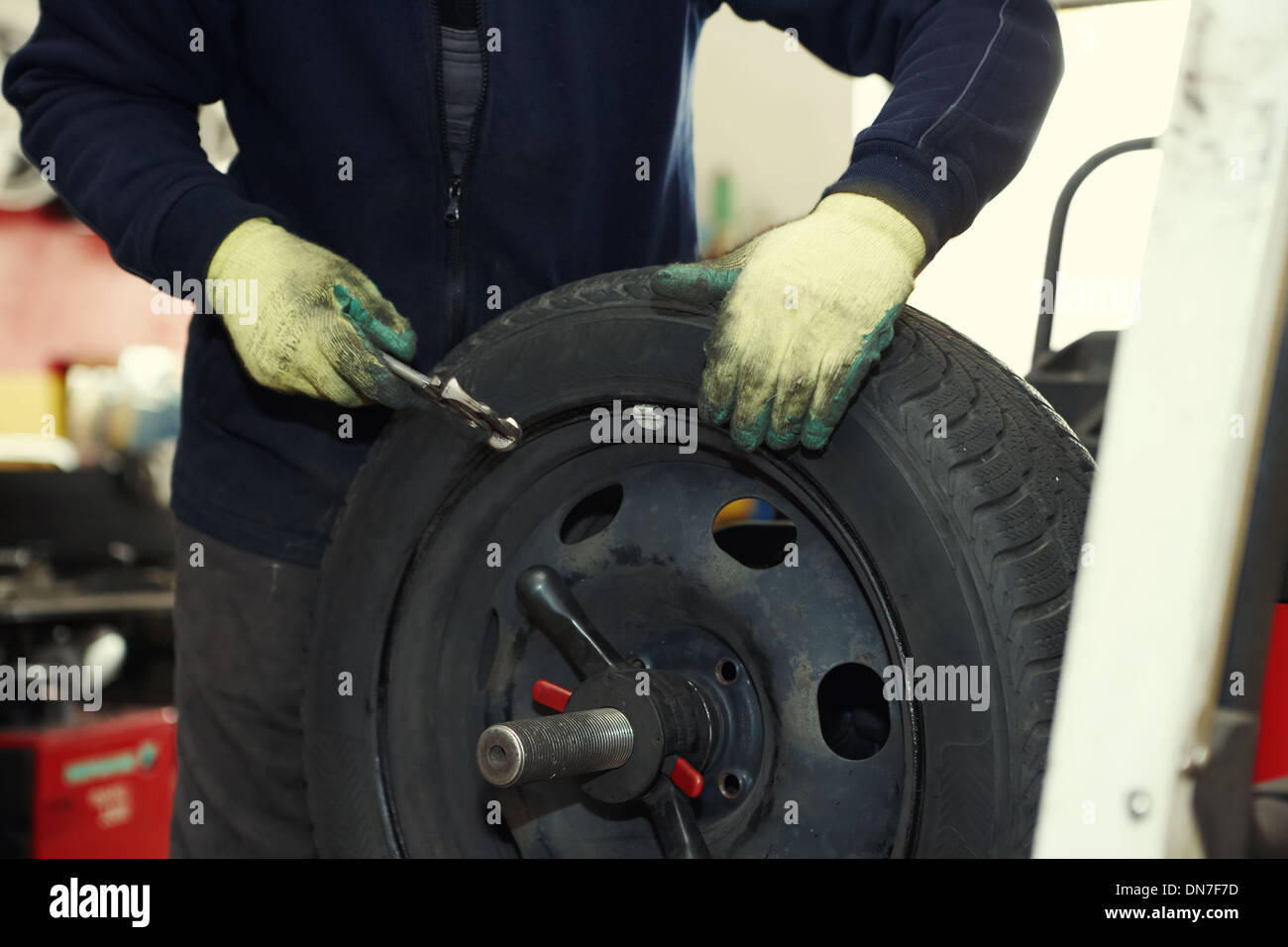Professional auto mechanic balancing wheel before changing it Stock ...