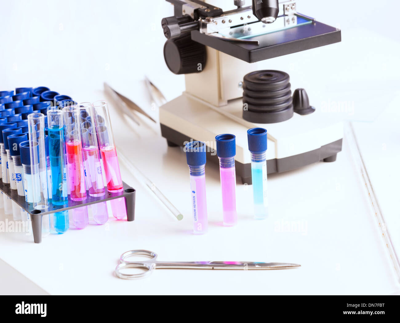 Laboratory equipment: microscope, test tubes filled with colored fluid ...