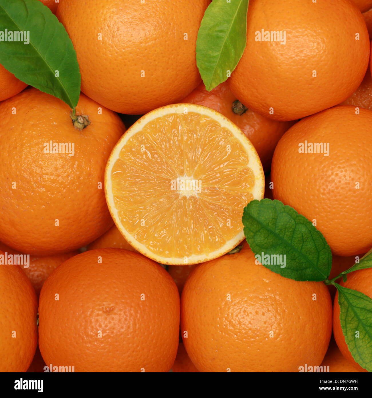 Group of oranges with leaves forming a background Stock Photo - Alamy