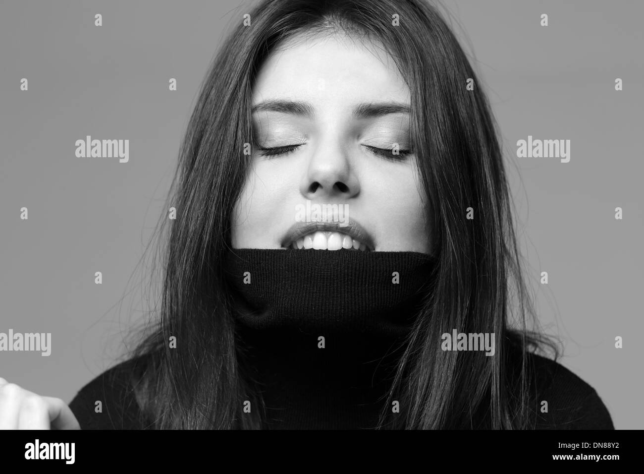 Black and white portrait of a young woman bites her sweater Stock Photo ...
