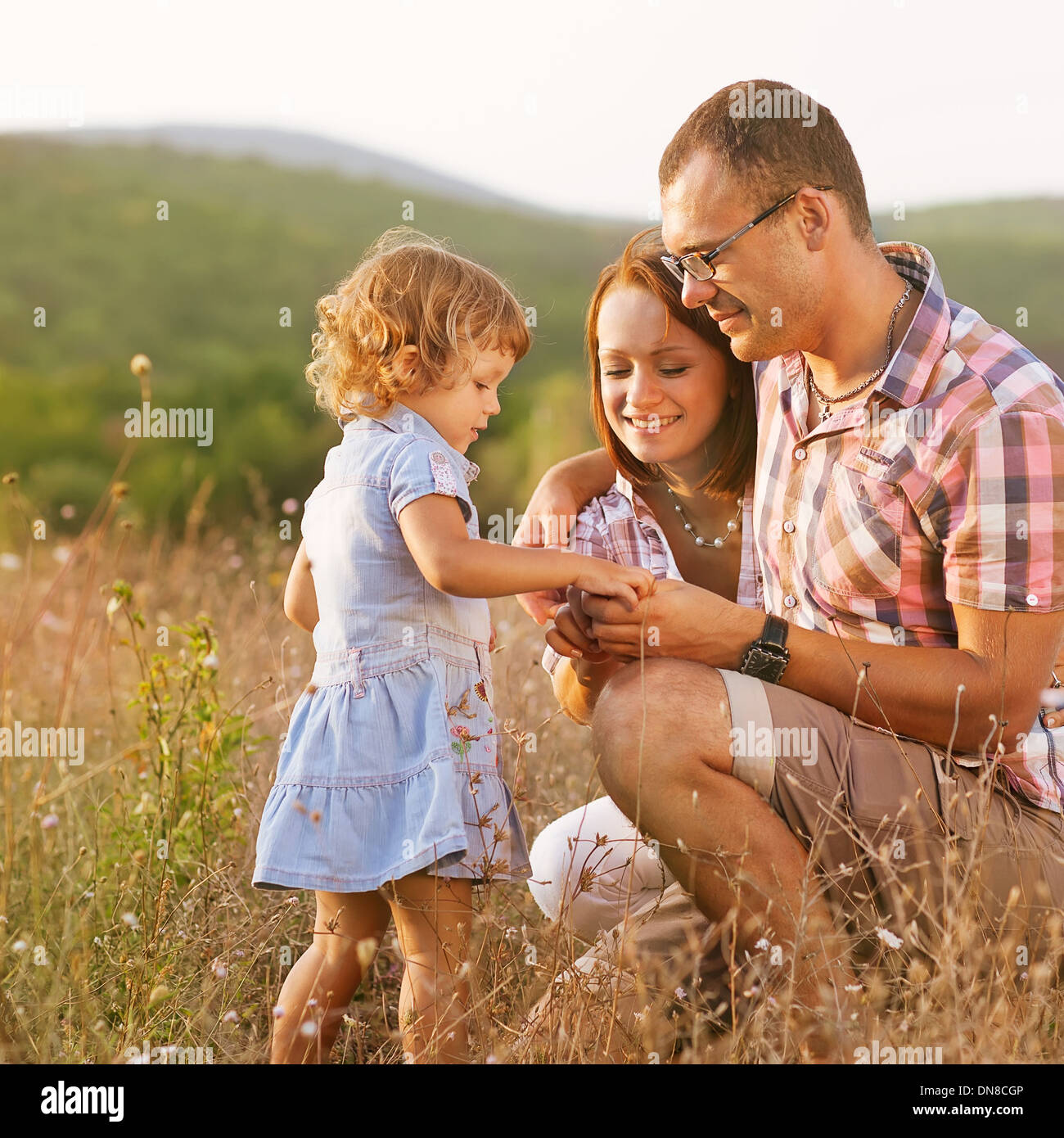Happy mother, father and daughter in sunset Stock Photo - Alamy