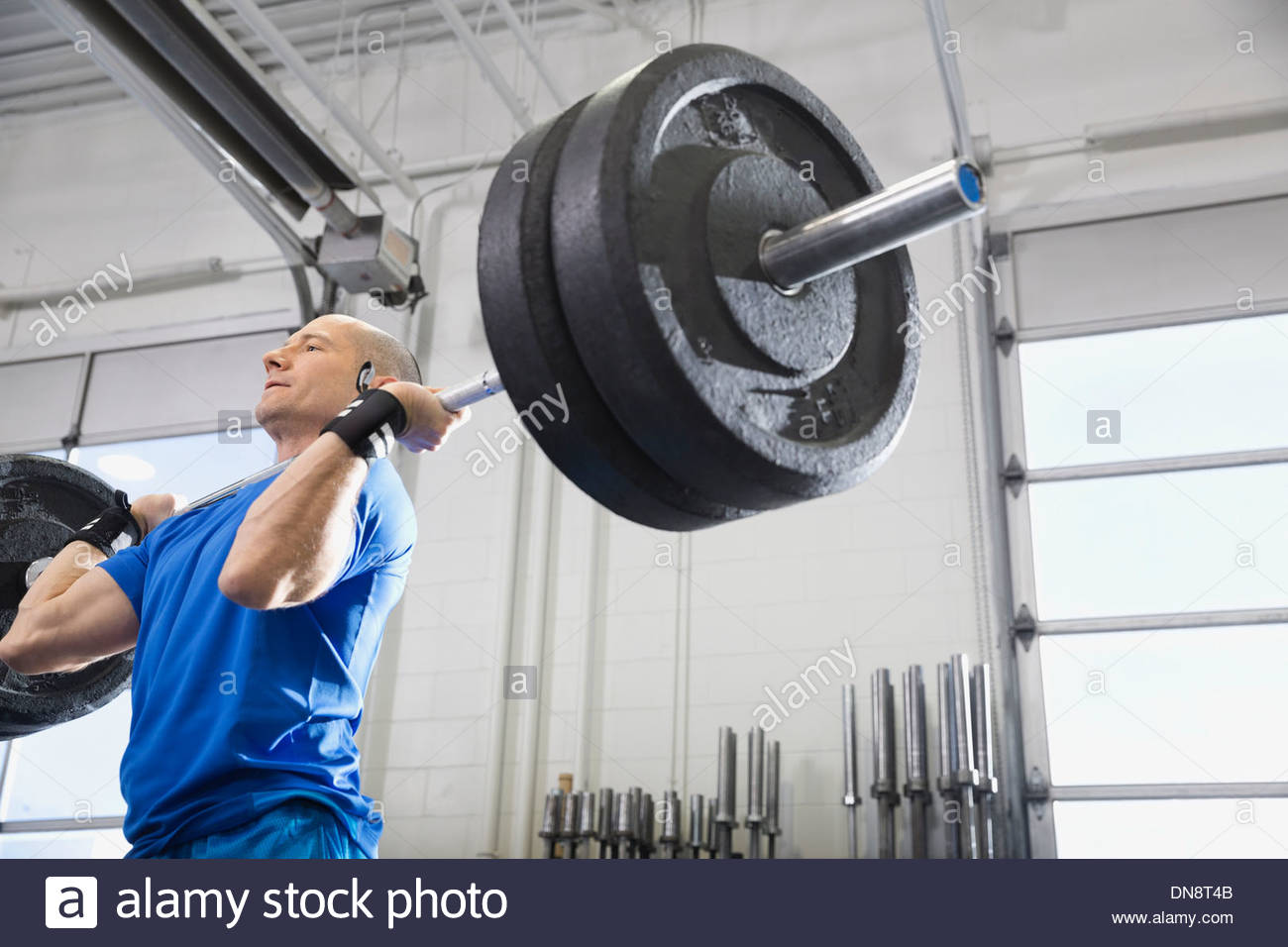 Man lifting barbell plate hi-res stock photography and images - Alamy