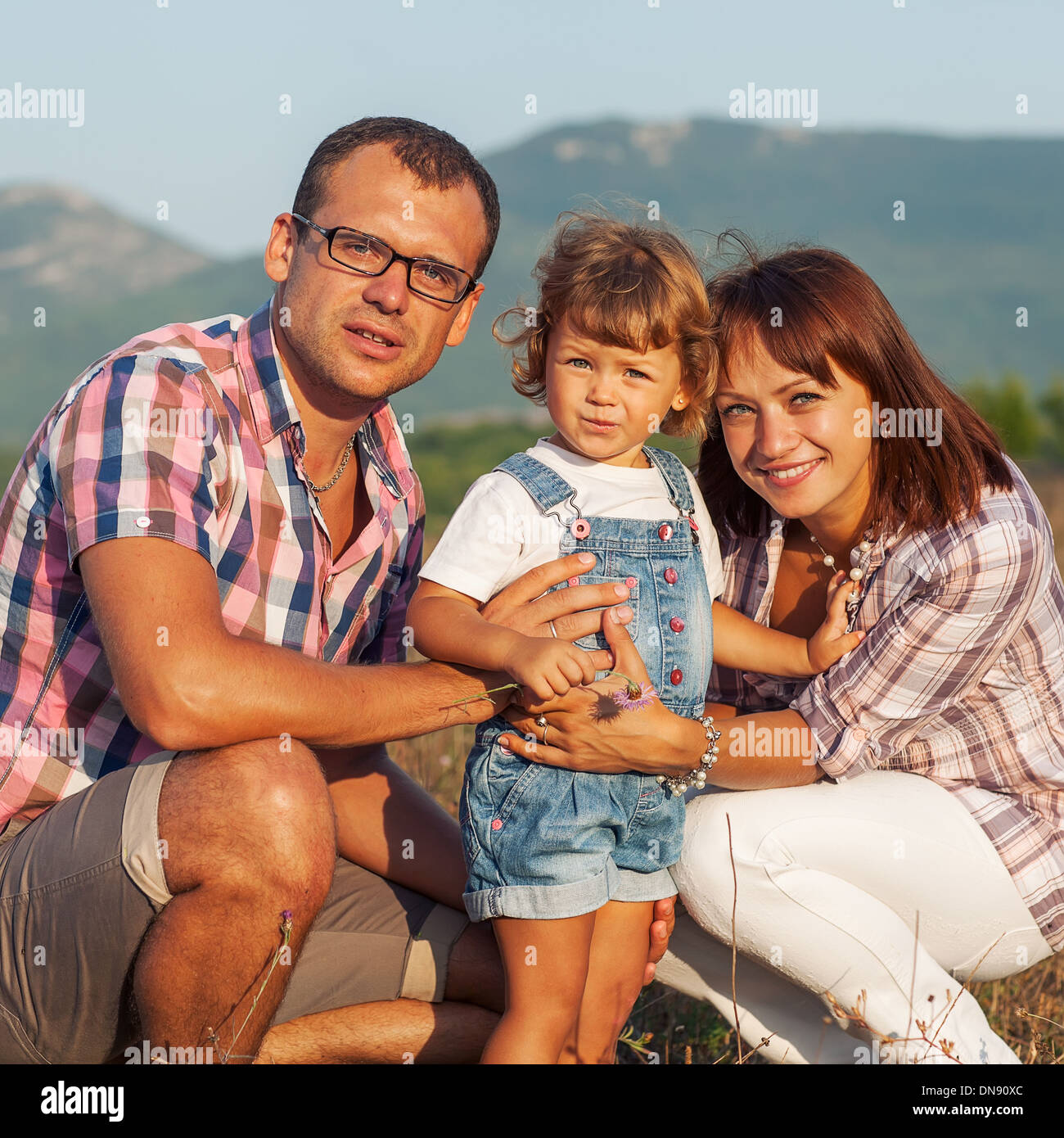Happy mother, father and daughter in sunset Stock Photo - Alamy