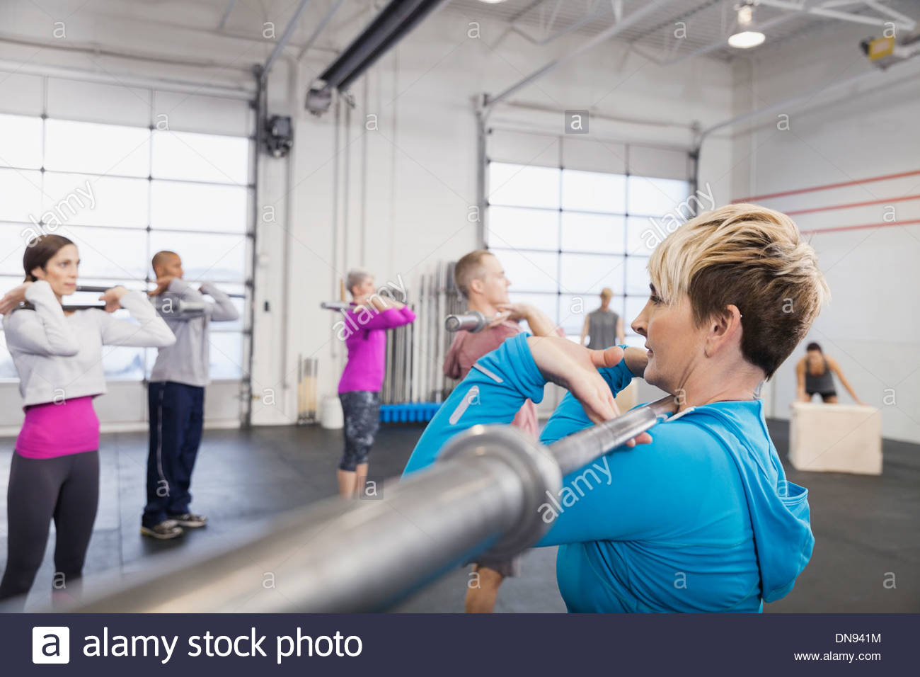 Group practicing clean lifts with barbells Stock Photo - Alamy