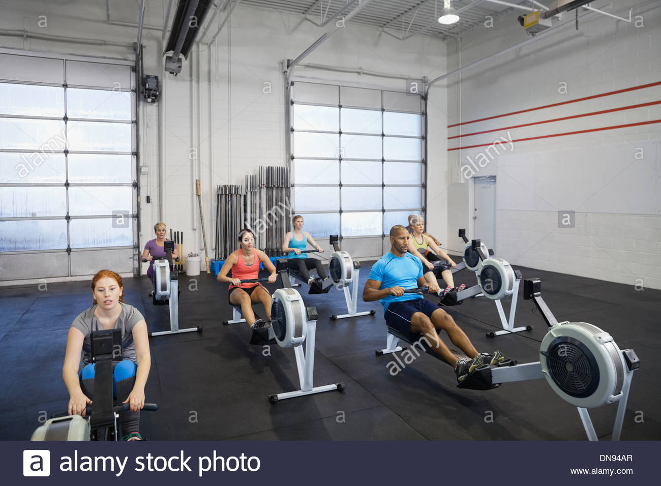 Group using rowing machine in gym Stock Photo - Alamy
