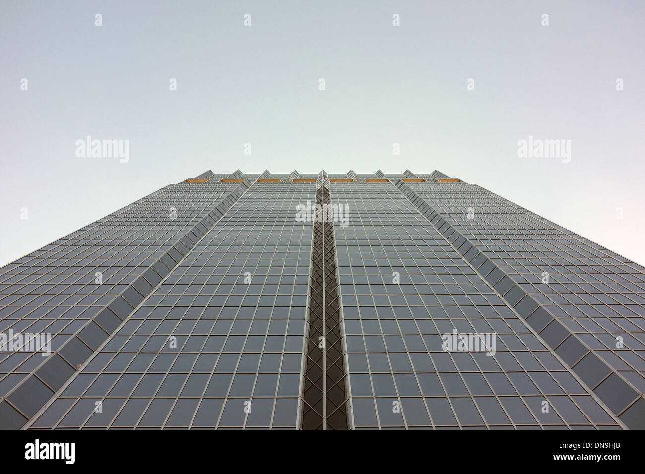 A low angled shot looking up at a tall glass skyscraper in Downtown ...