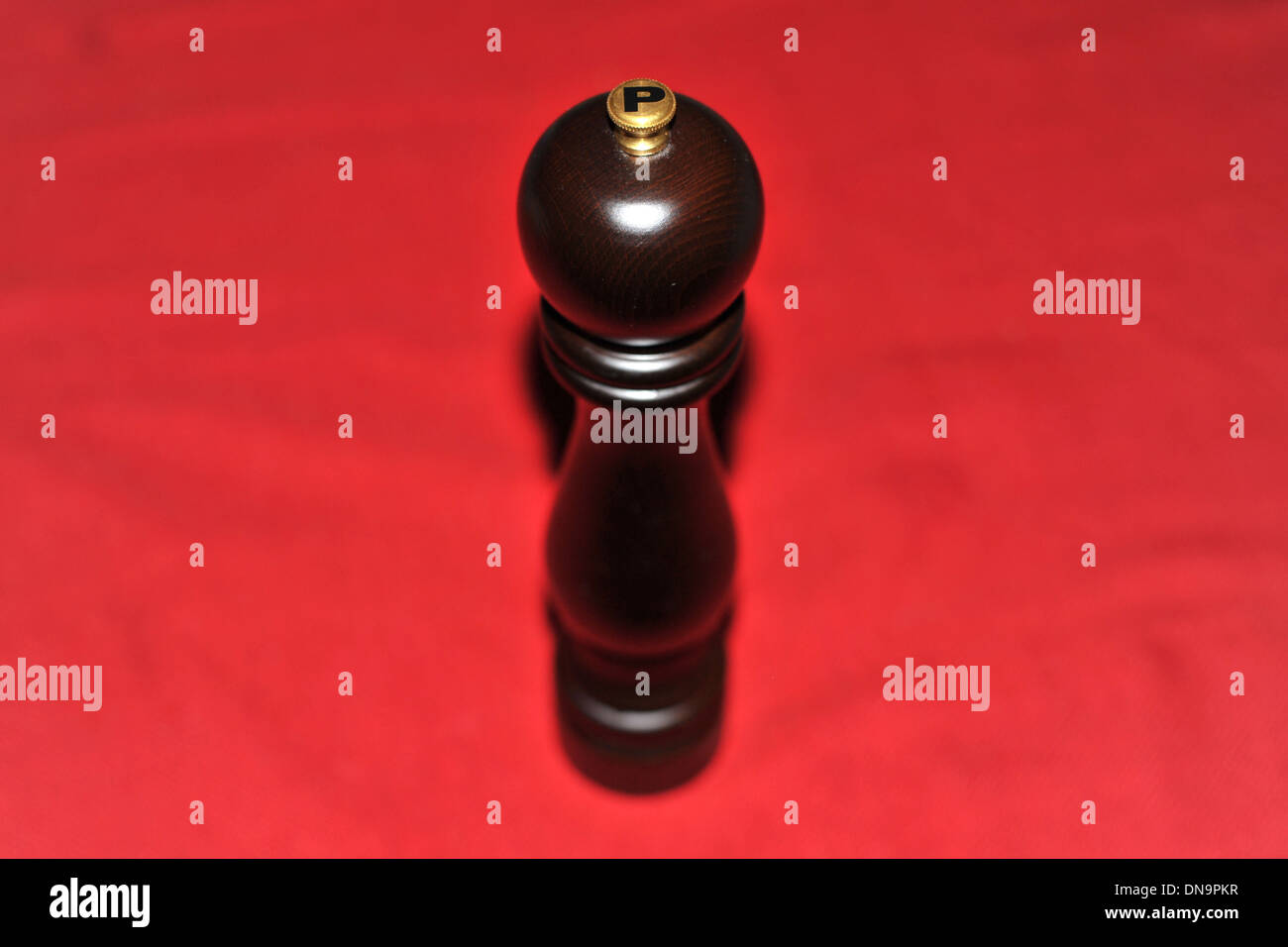 A large pepper grinder photographed against a red background Stock ...