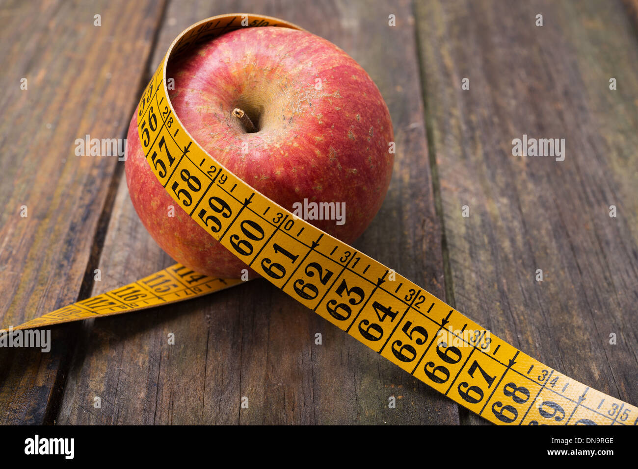 apple with tape measure. wooden background Stock Photo - Alamy
