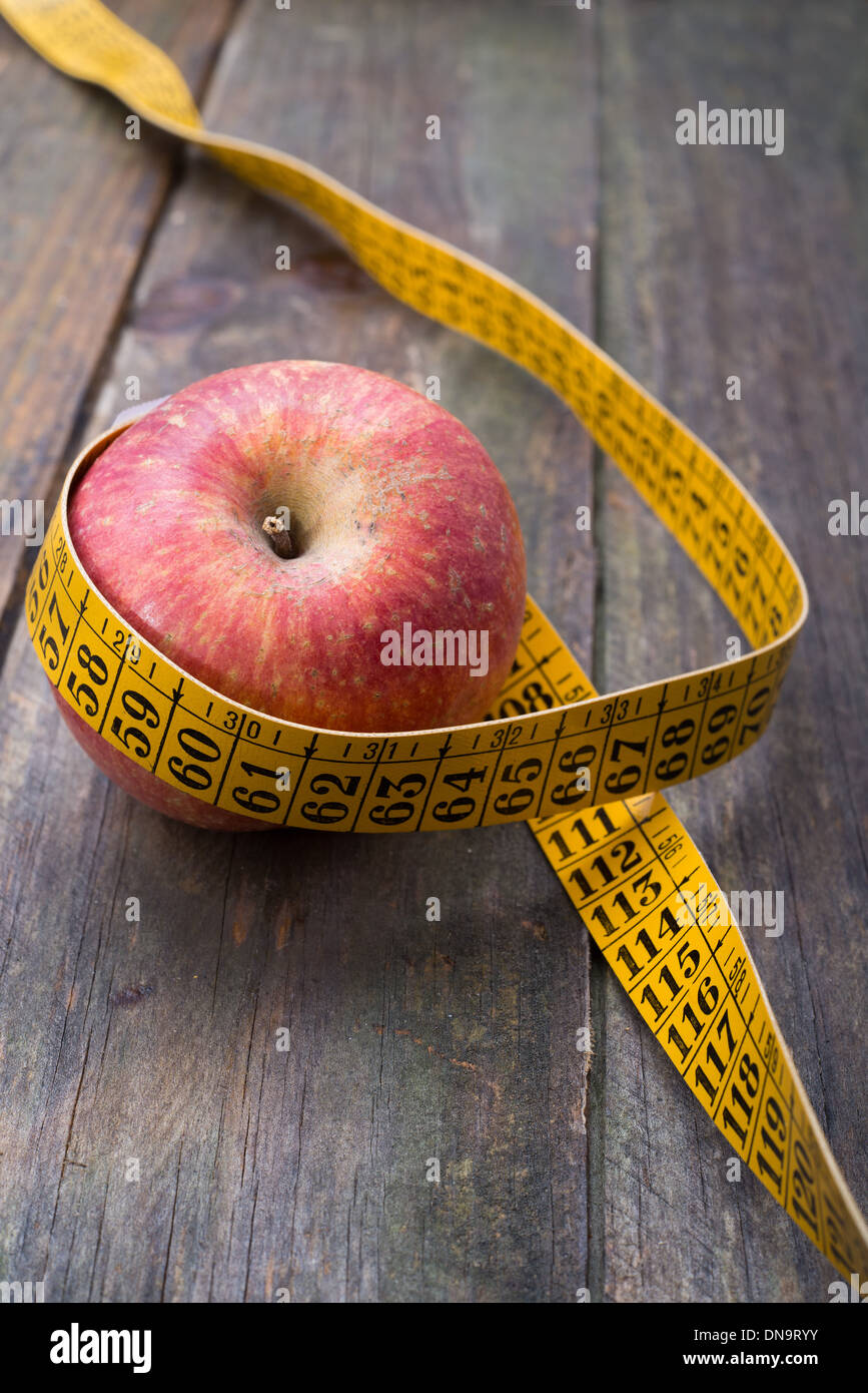 apple with tape measure. wooden background Stock Photo - Alamy
