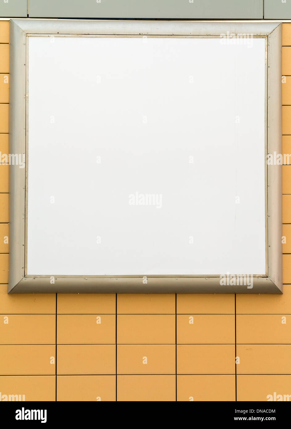 Empty blank square white advertising billboard on orange tiled wall ...