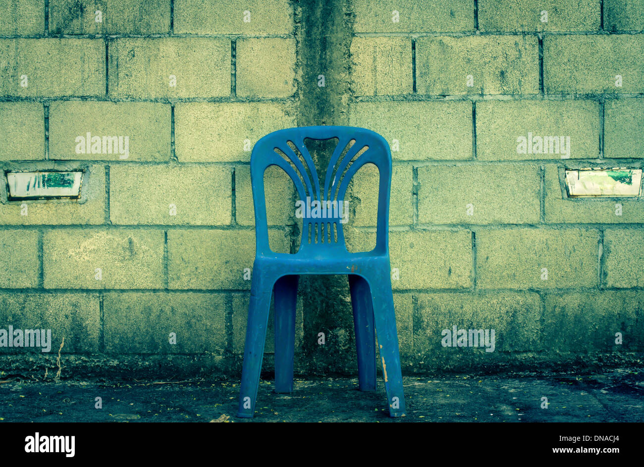 One center blue chair on concrete block background in vintage style ...