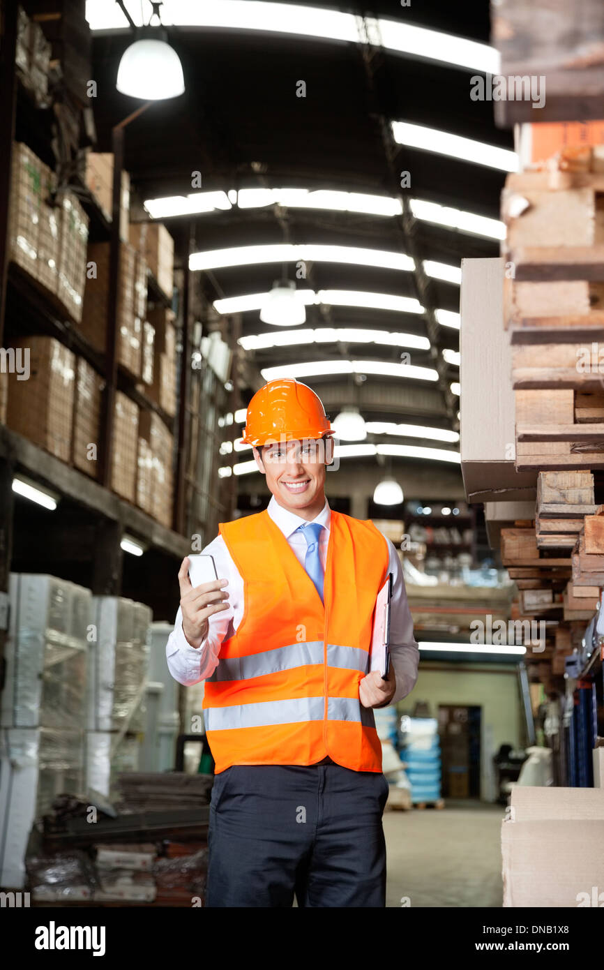 Male Supervisor Using Cell Phone At Warehouse Stock Photo - Alamy