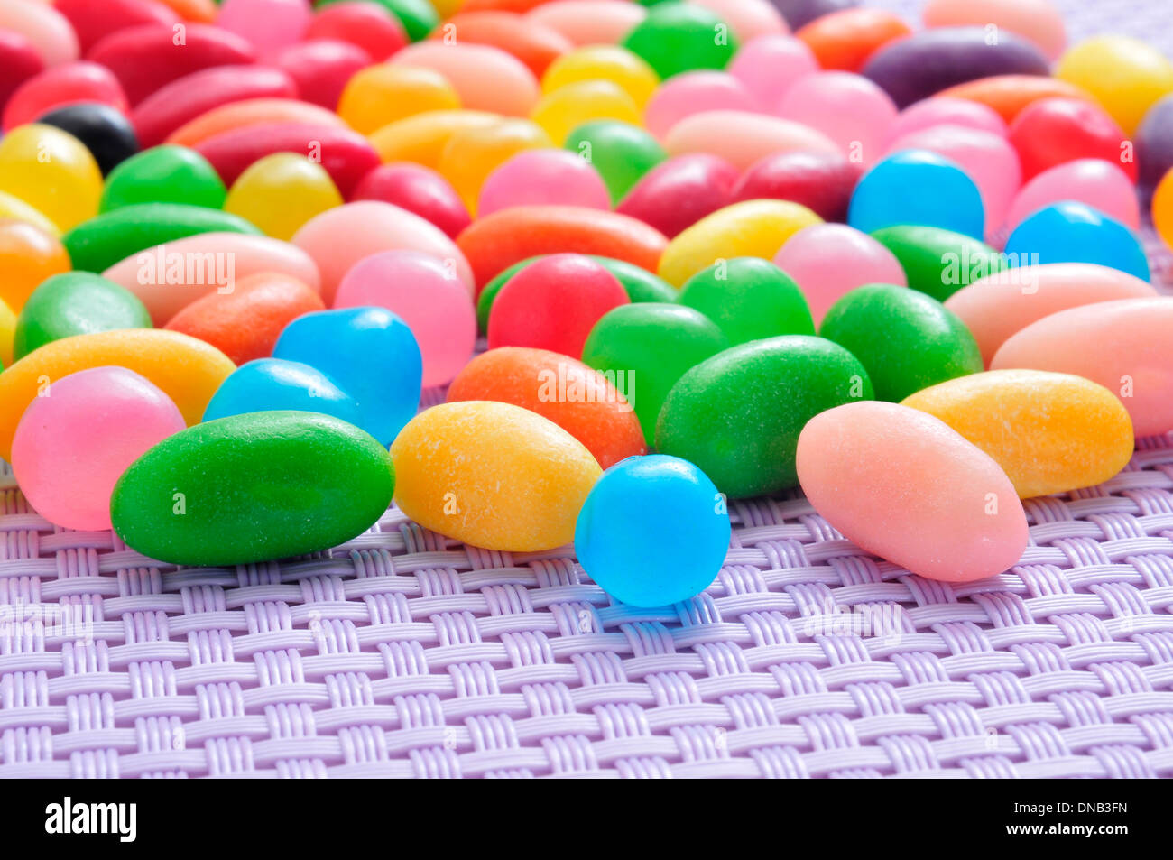 a pile of jelly beans of different colors on a violet background Stock ...