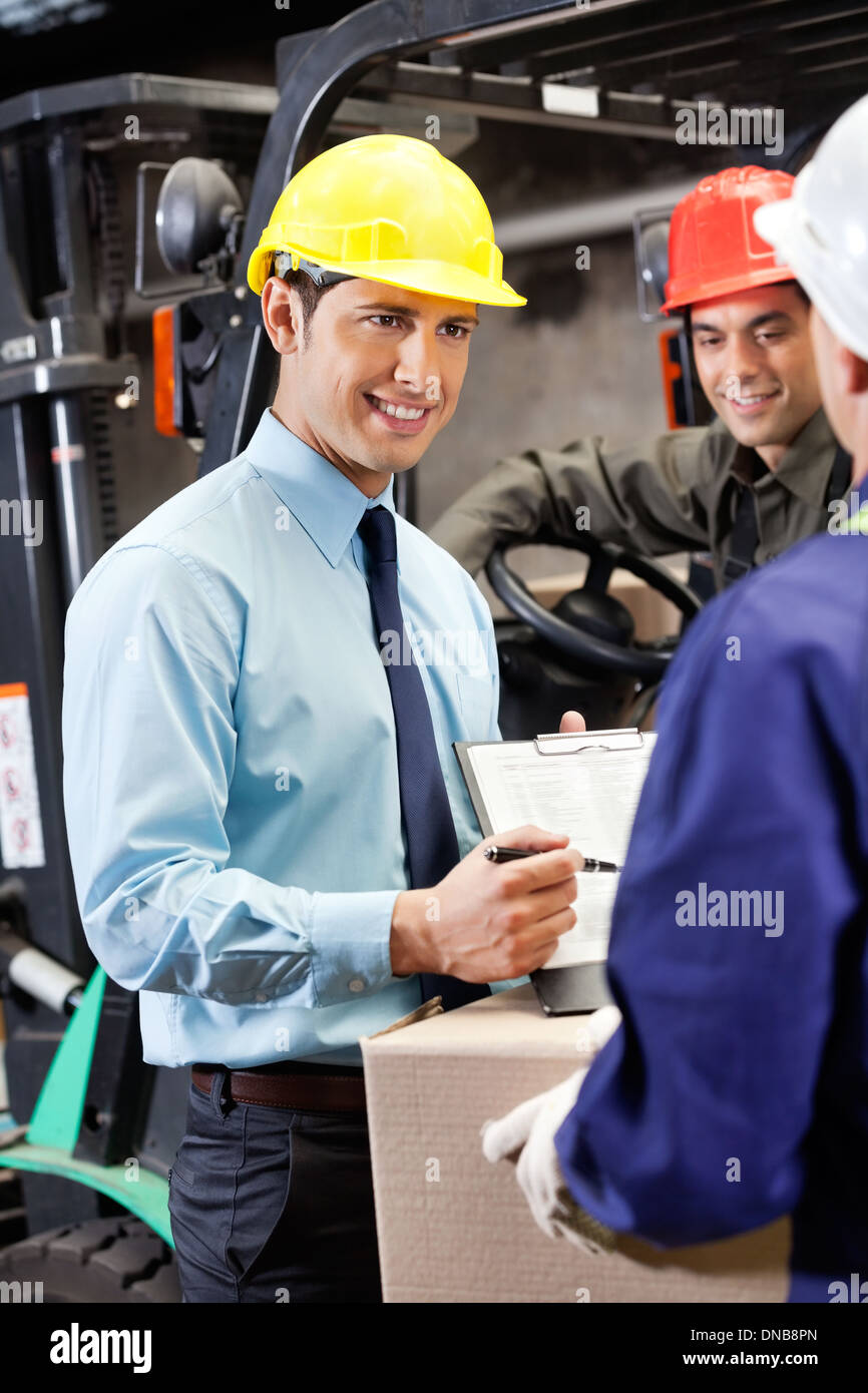 Male Supervisor Showing Clipboard To Foreman Stock Photo - Alamy
