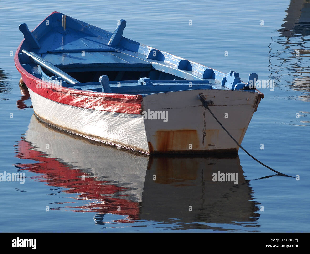 blue fishing boat and reflection in the sea Stock Photo - Alamy