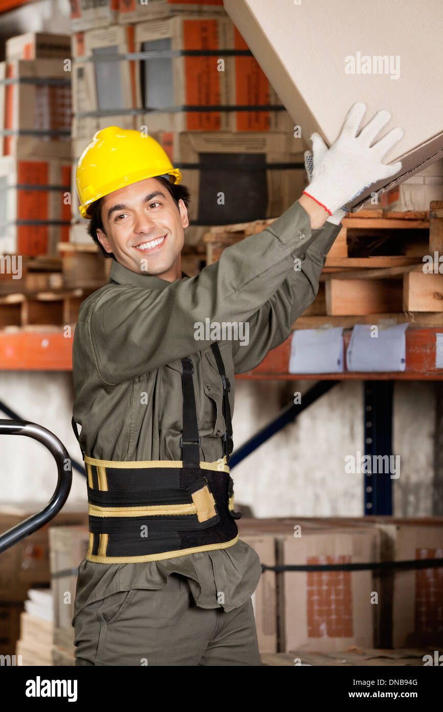 Foreman Lifting Cardboard Box At Warehouse Stock Photo - Alamy
