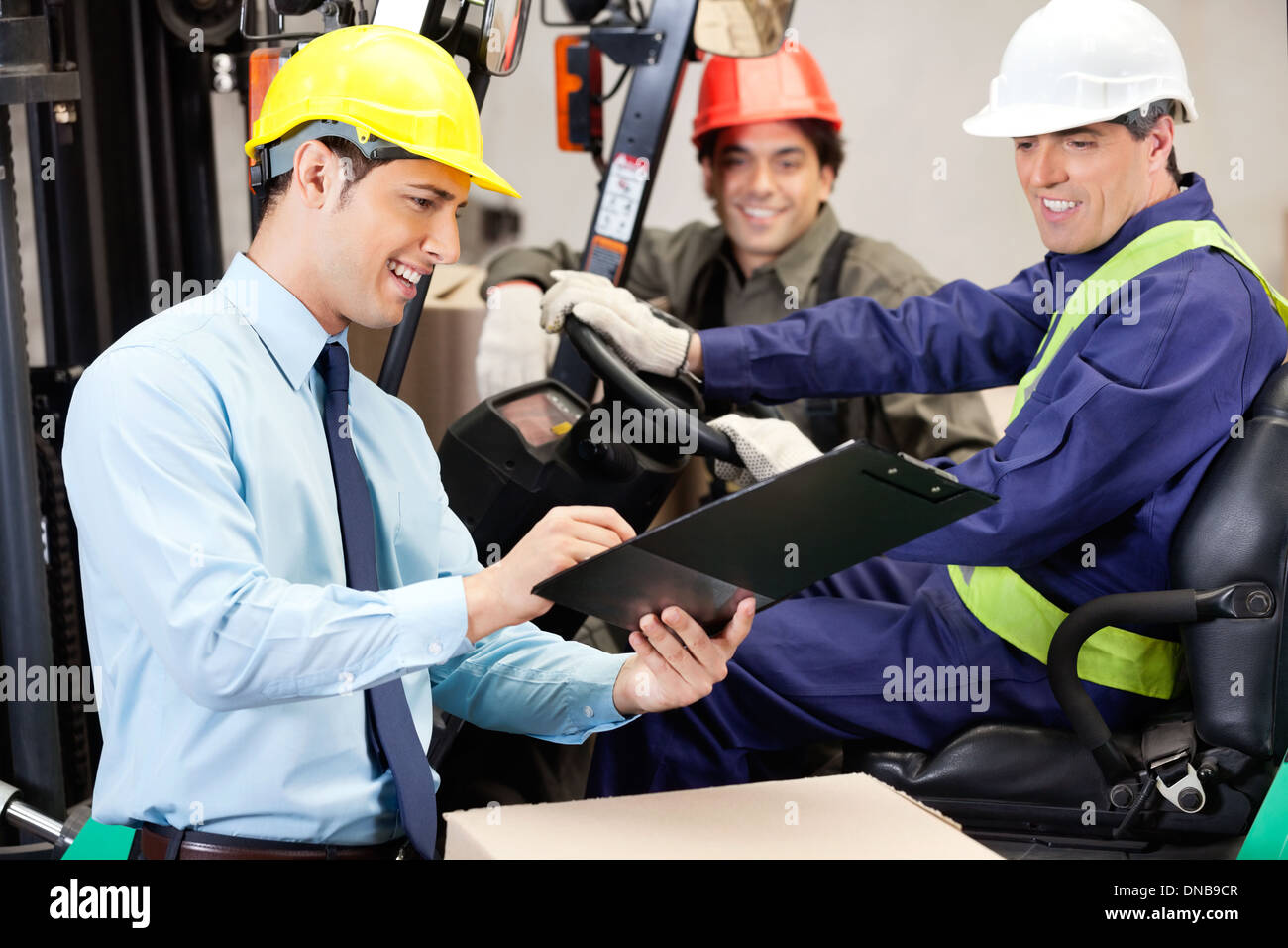 Male Supervisor Communicating With Forklift Driver And Foreman Stock ...