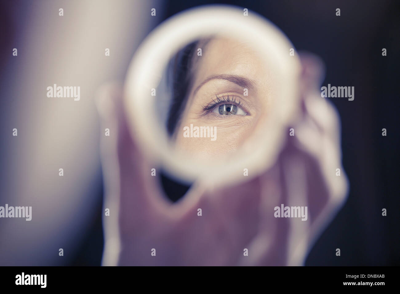 A woman looking in a hand mirror Stock Photo - Alamy