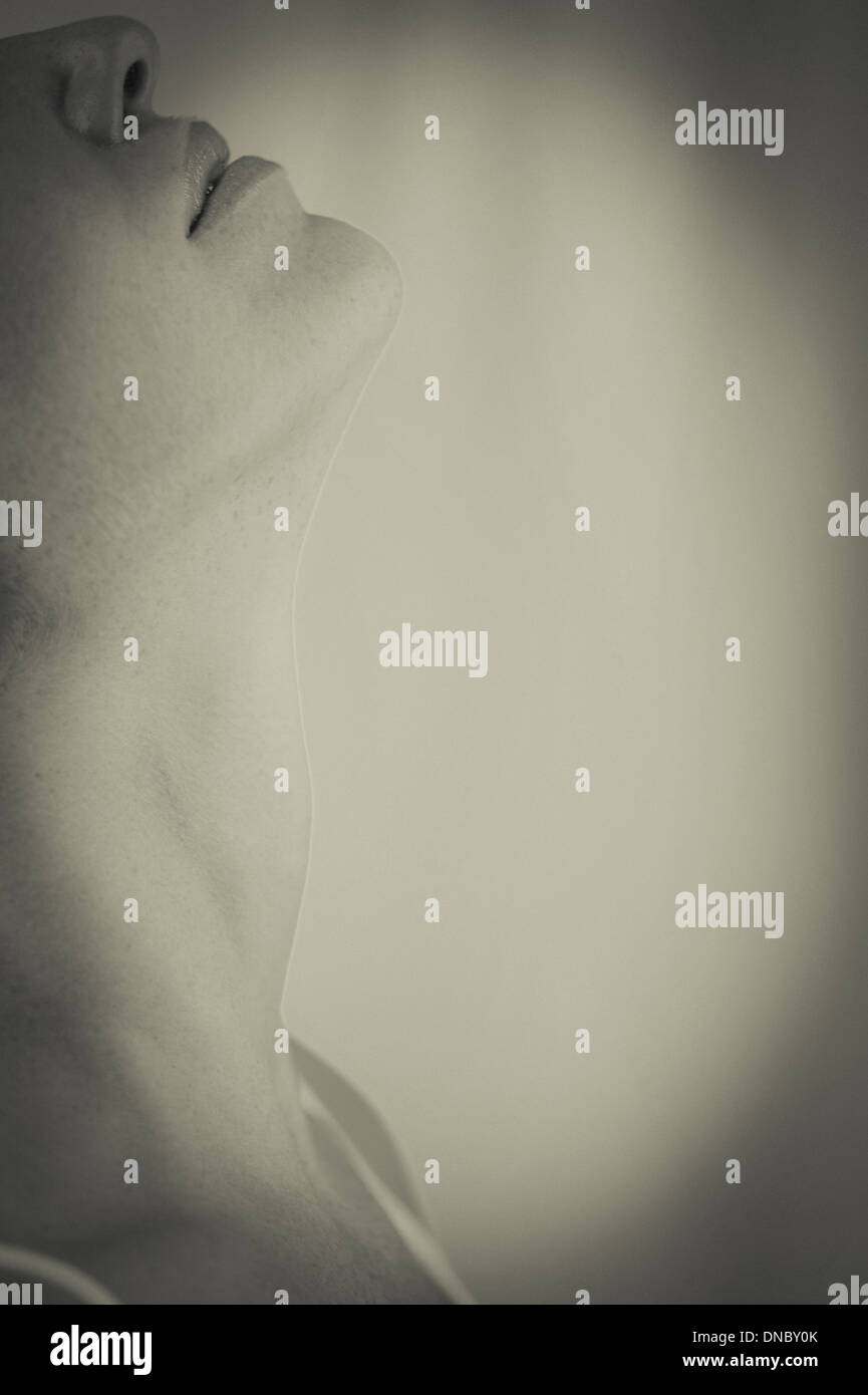 A young woman tilting her head back, side view Stock Photo - Alamy