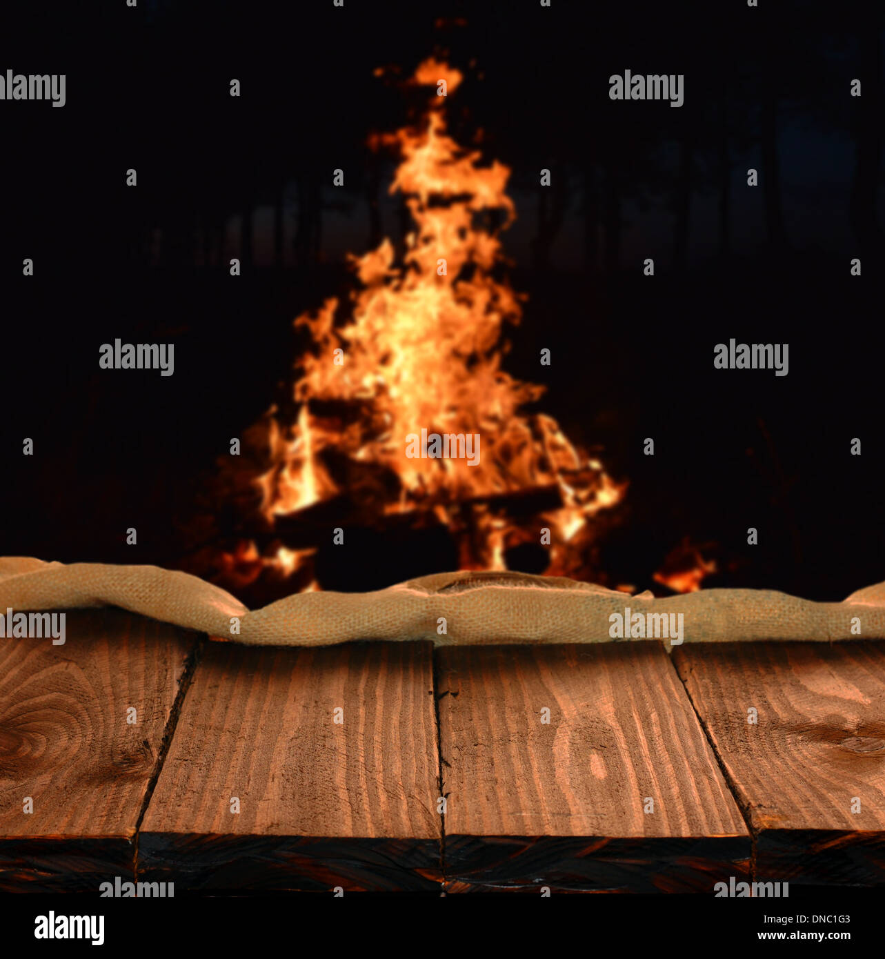 Empty wooden table and campfire in background. Great for product ...
