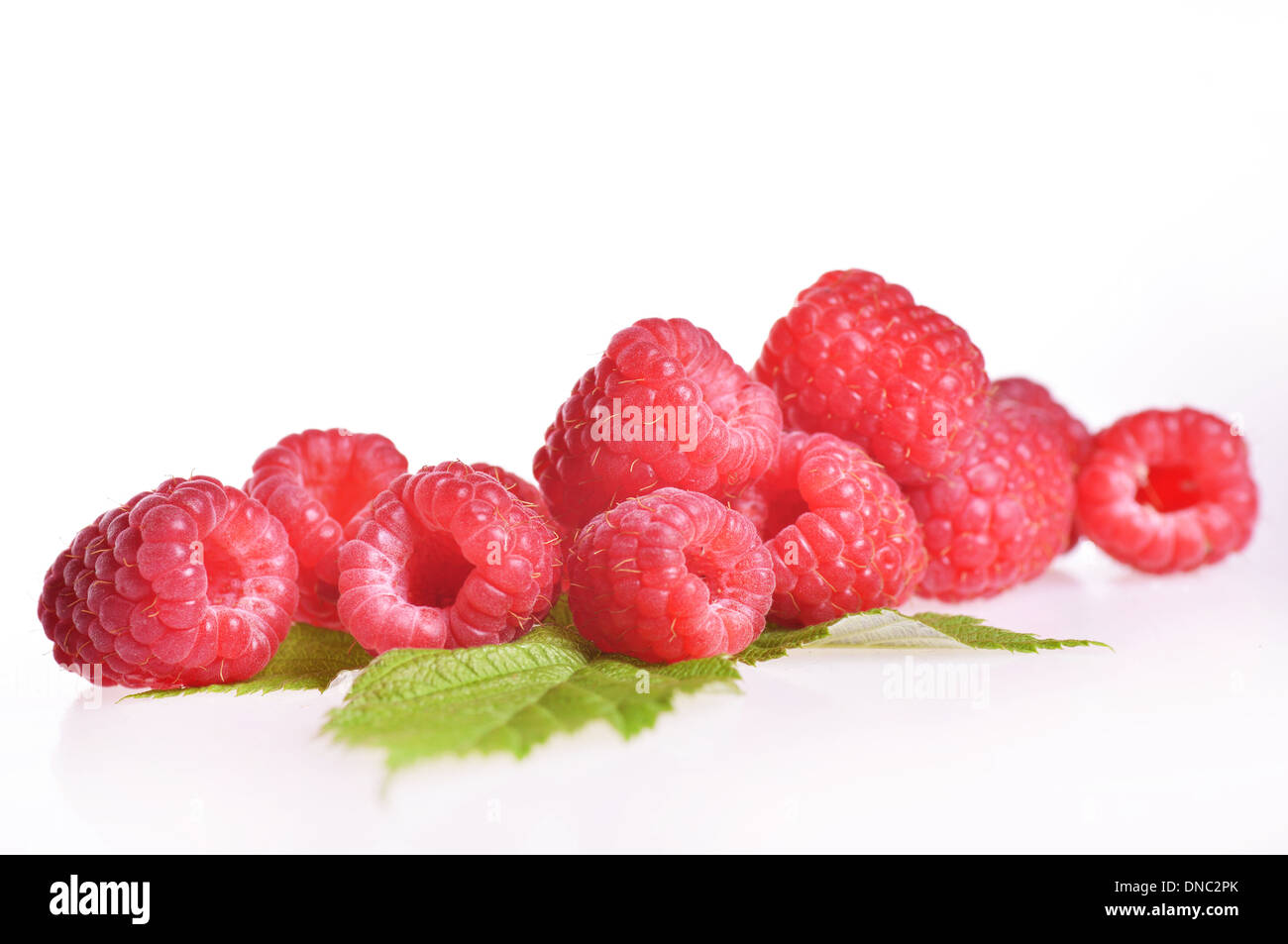Very tasty summer raspberries with green leaf Stock Photo - Alamy