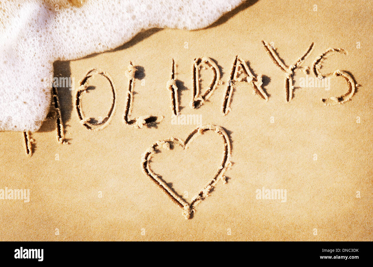 "Holiday" written in the sand on the beach Stock Photo - Alamy