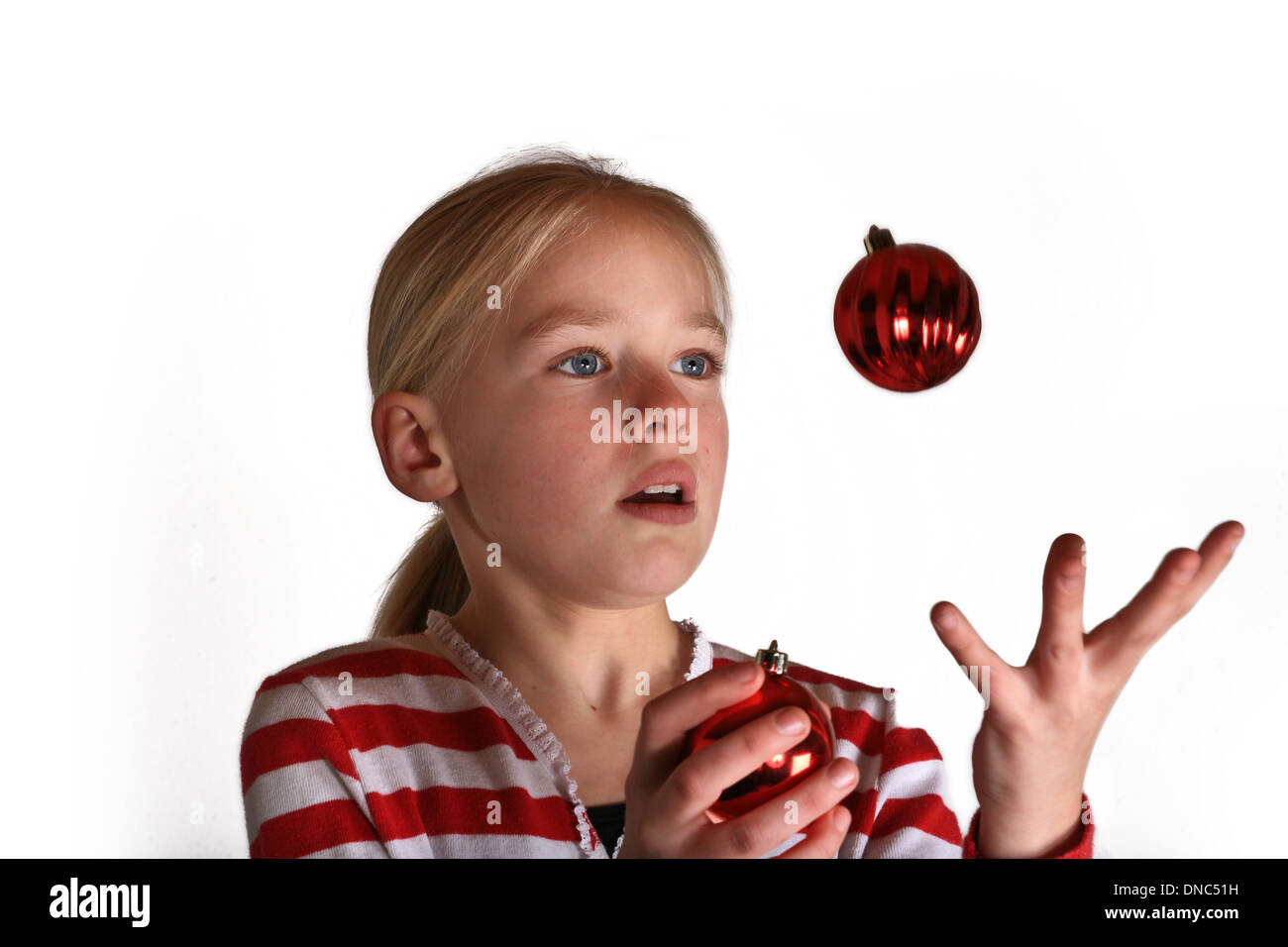 portait of a cute scandinavian girl in studio, juggling with a ...