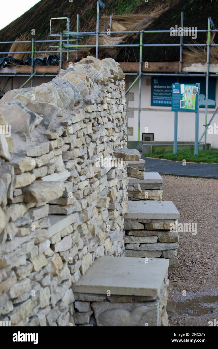 Newly built stone wall with stone seating Stock Photo - Alamy