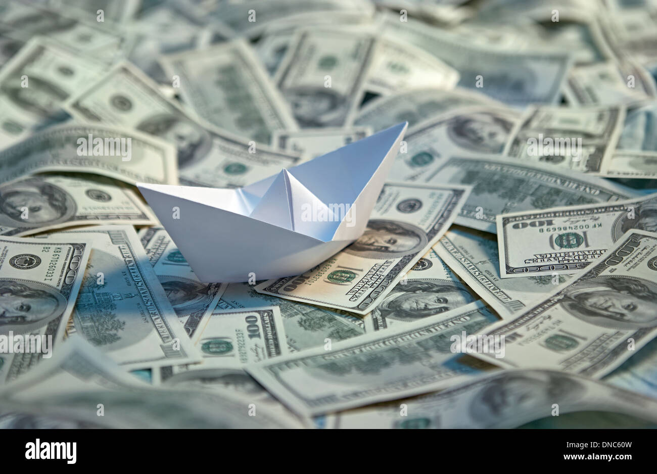 Origami paper boat at sea of money Stock Photo - Alamy