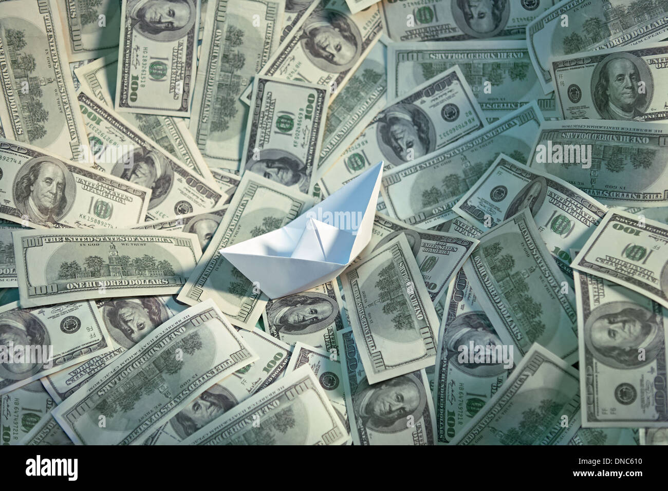 Paper boat floating on the sea of money Stock Photo - Alamy