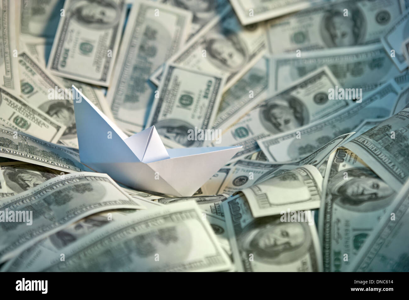 Paper ship at sea of money Stock Photo - Alamy