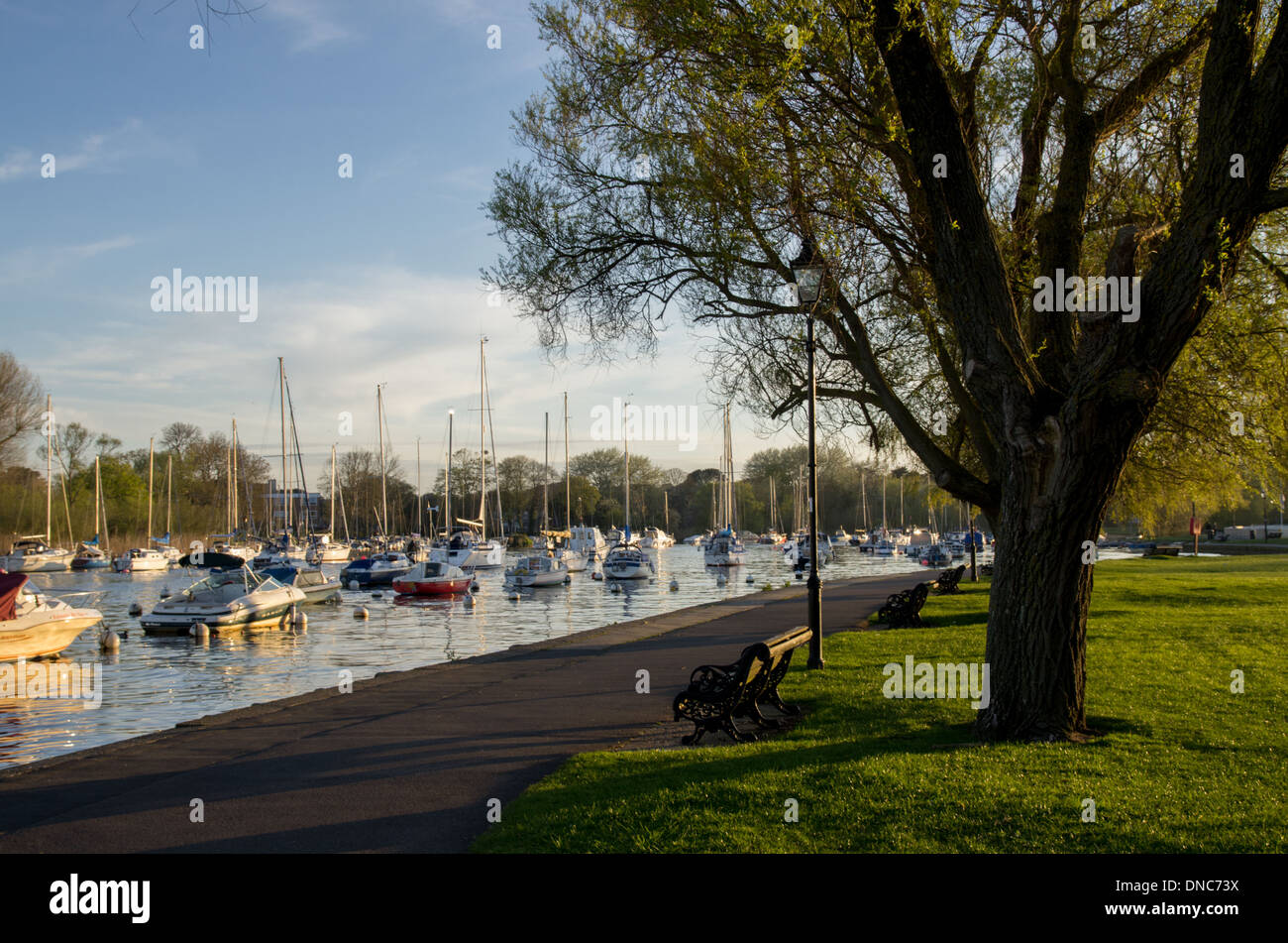 A sunset scene on river Stour with path and benches along the canal and ...