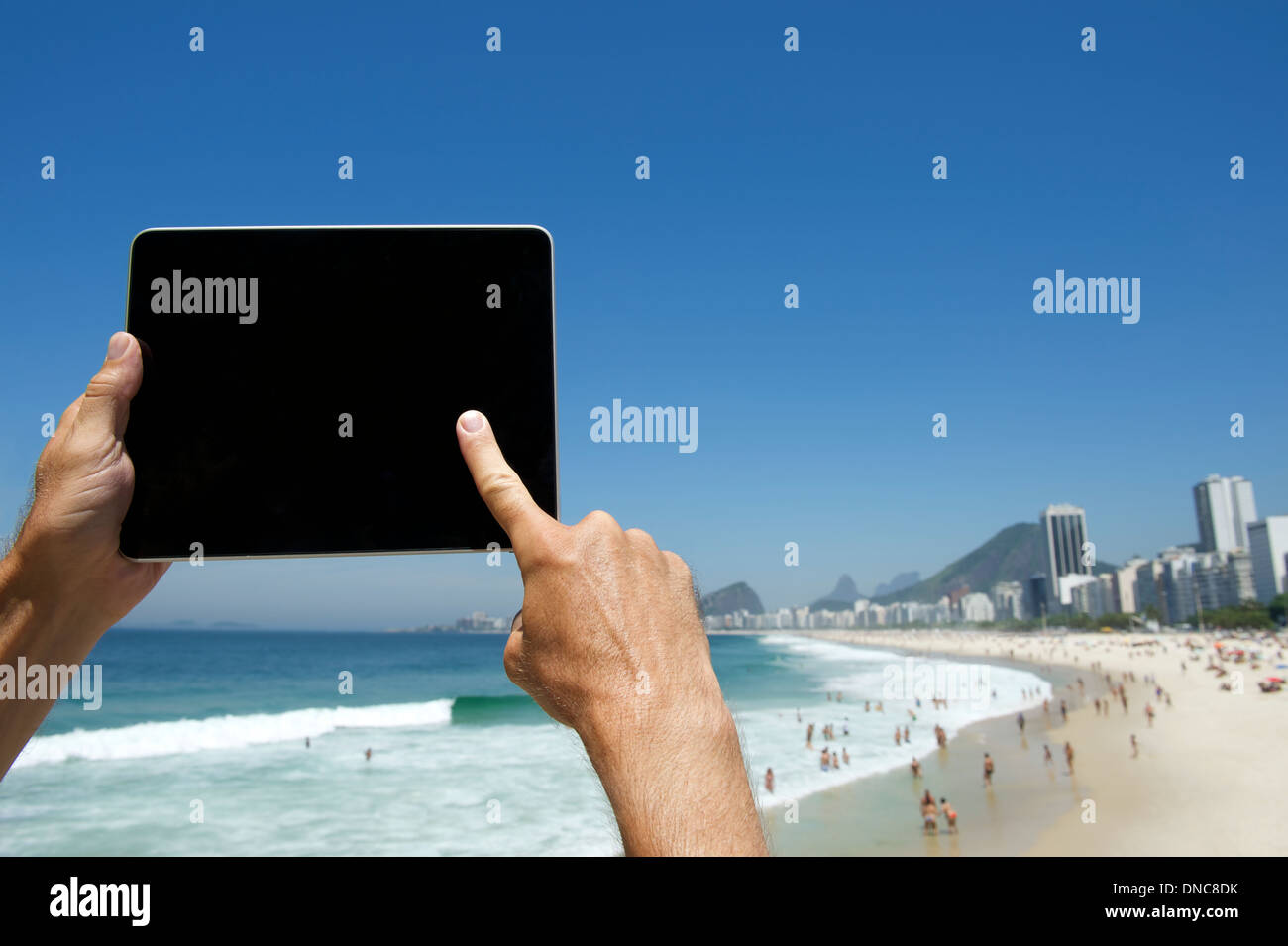 Traveling tourist using tablet computer at Copacabana Beach Rio de ...