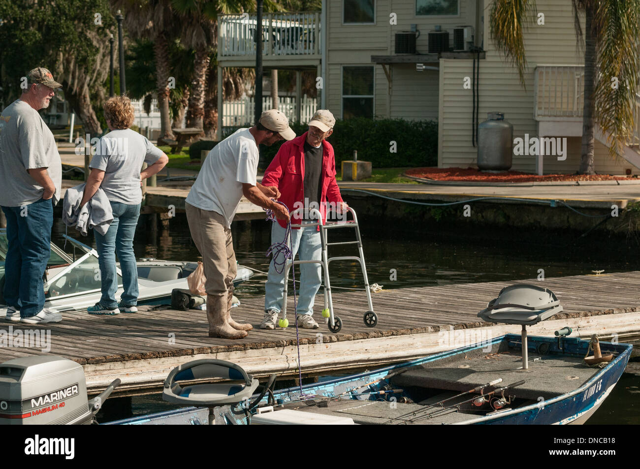 A handicap man being helped to his boat by a concerned citizen dockside ...