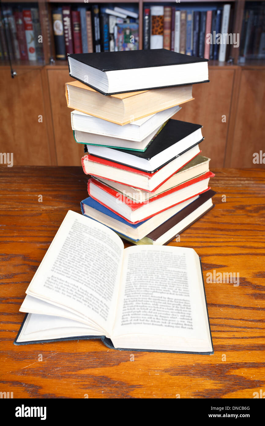 stack of books and open book with blur font on wooden table near ...