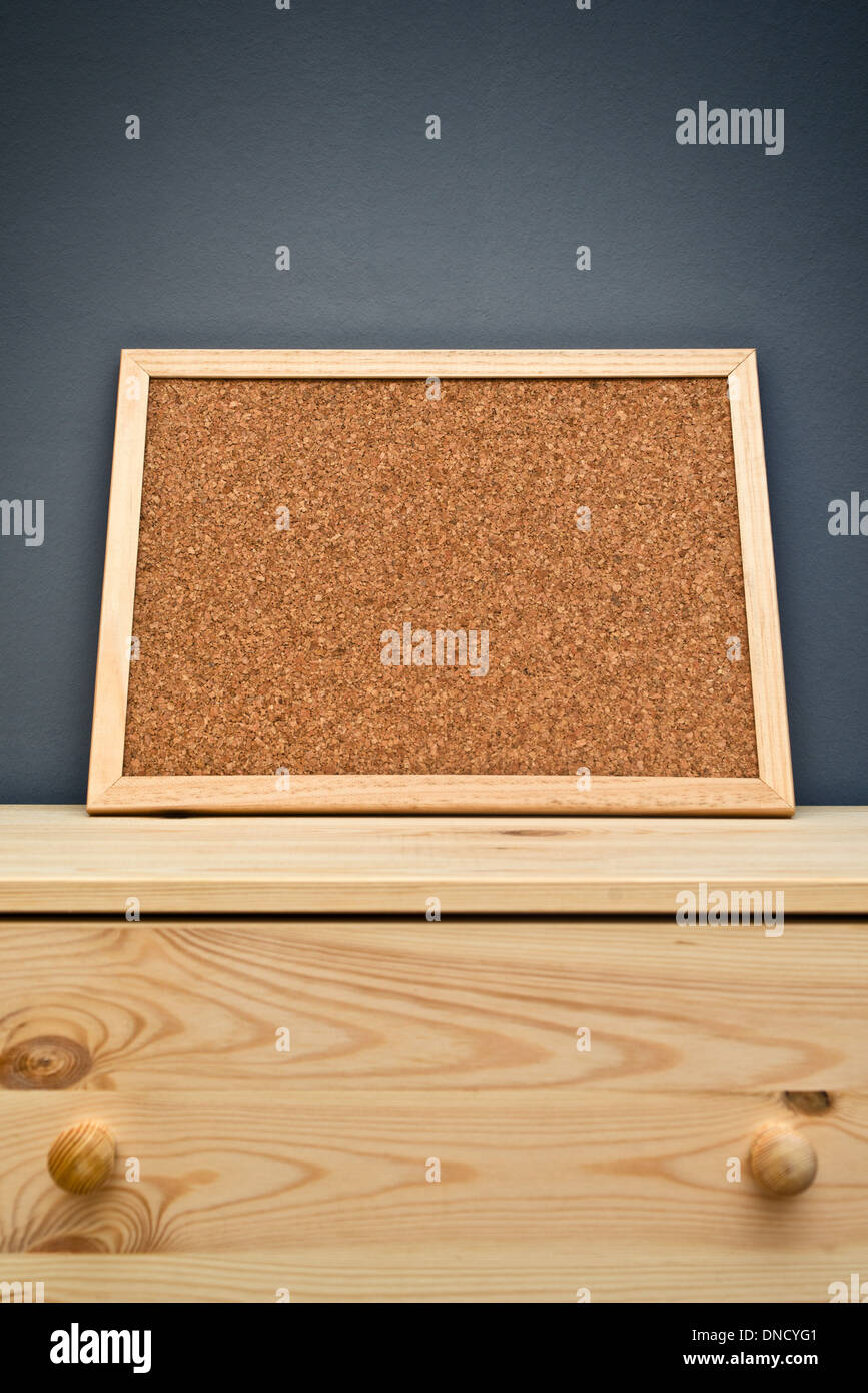 Empty cork memory board on wooden cabinet in a room with copy space ...