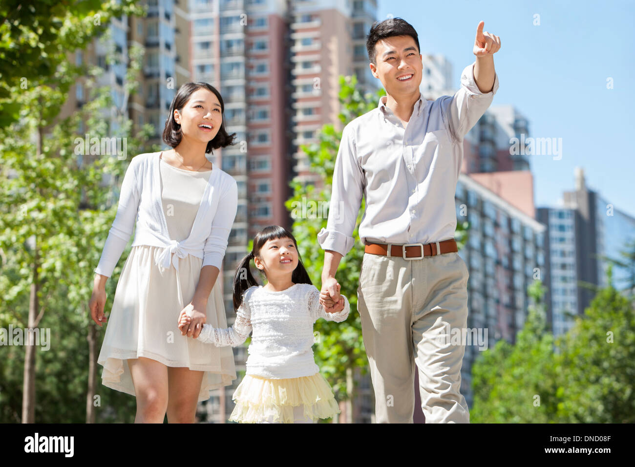 Young parents with daughter strolling hand in hand Stock Photo - Alamy