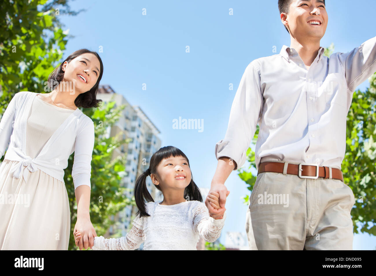 Young parents with daughter strolling hand in hand Stock Photo - Alamy