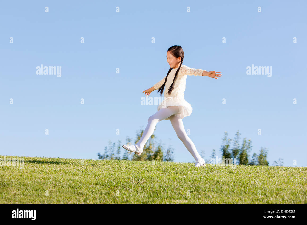 Happy little girl striding forward in a park Stock Photo - Alamy