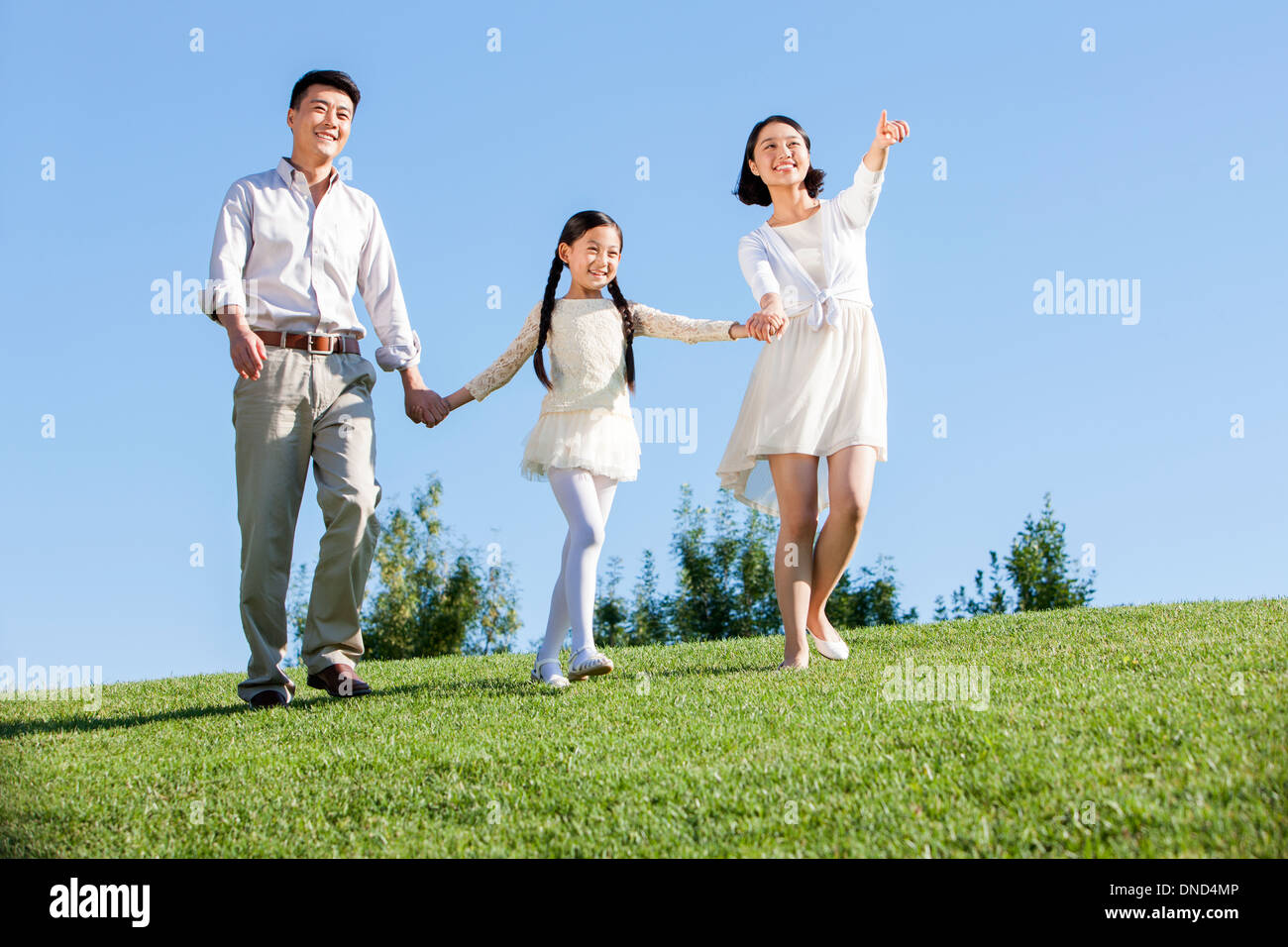 Happy young family strolling in a park Stock Photo - Alamy