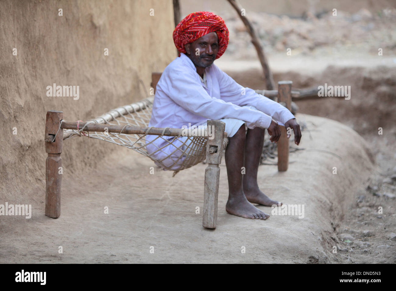 Tribal man sitting on a cot outside his house, Madhya Pradesh, India ...