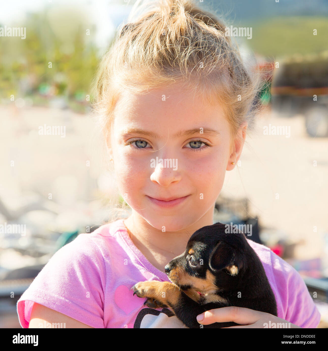 Blond kid girl playing with puppy dog smiling with blue eyes Stock ...