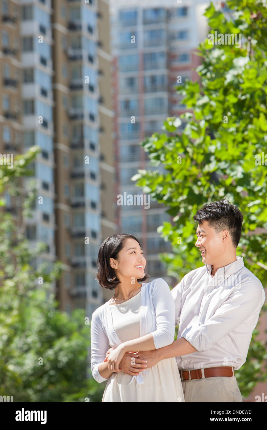 Cheerful young couple arm around outdoors Stock Photo - Alamy
