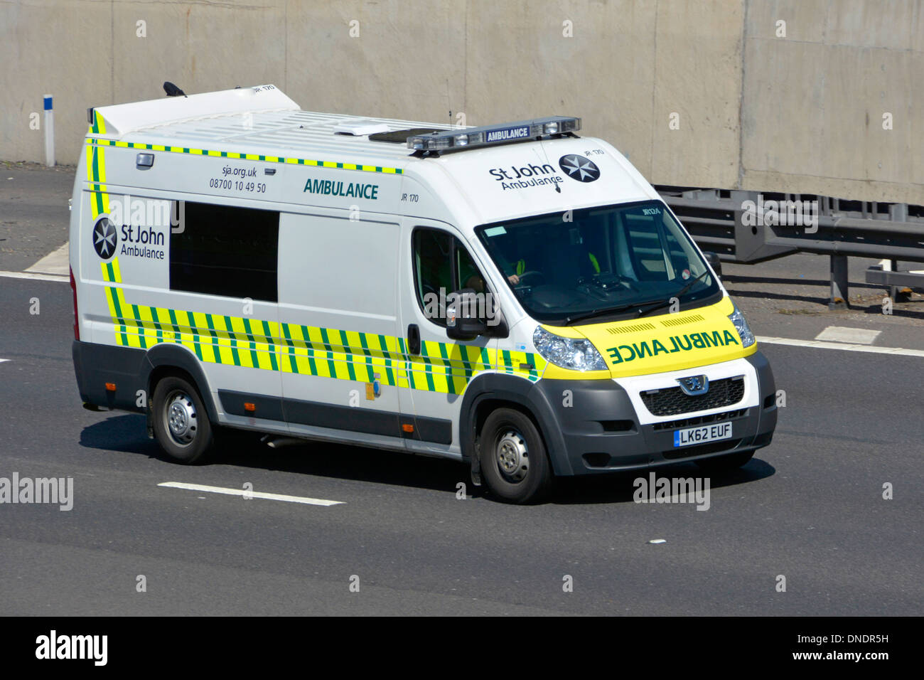 St John ambulance with reverse front lettering driving along motorway ...