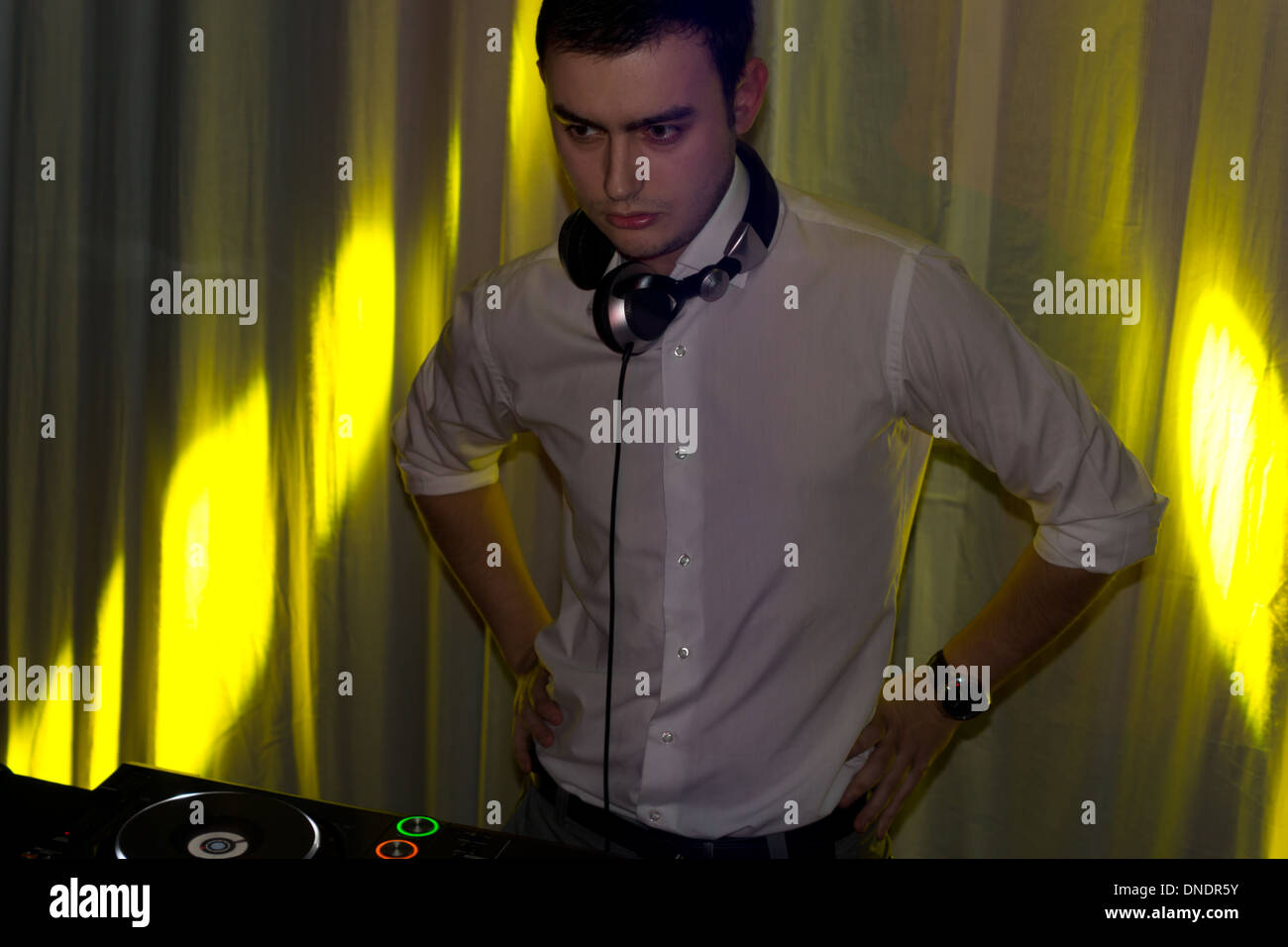 Disc jockey at a club standing over his music deck Stock Photo - Alamy