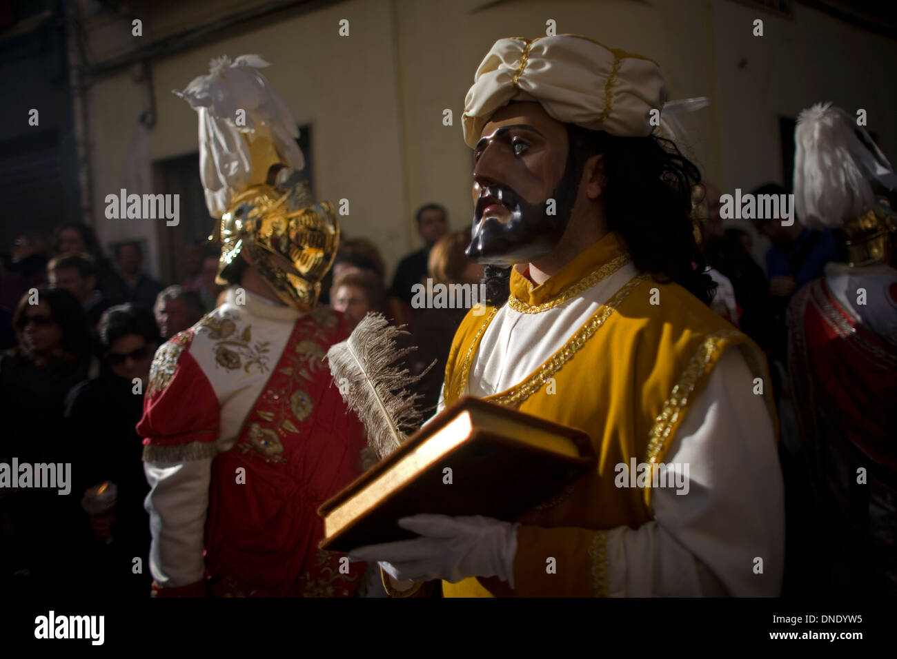 A masked man dressed as a biblical character holds a book during Easter ...